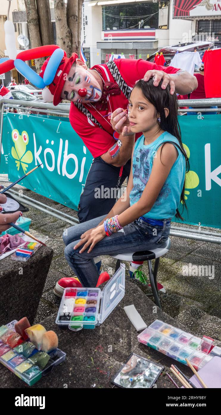Makeup artist applying makeup to the cheek of a young girl in San José ...