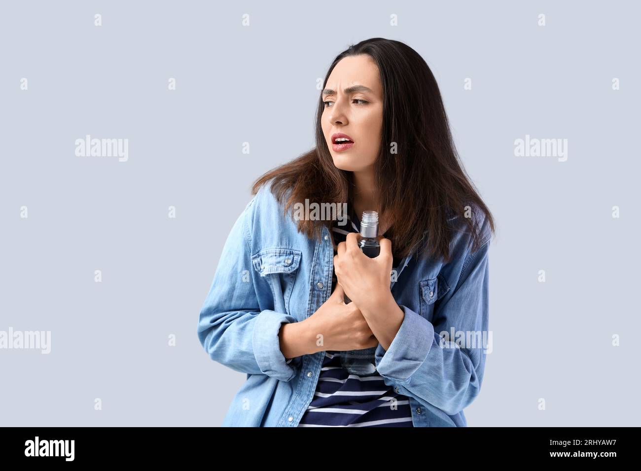 Young woman with bottle of vodka on light background Stock Photo - Alamy