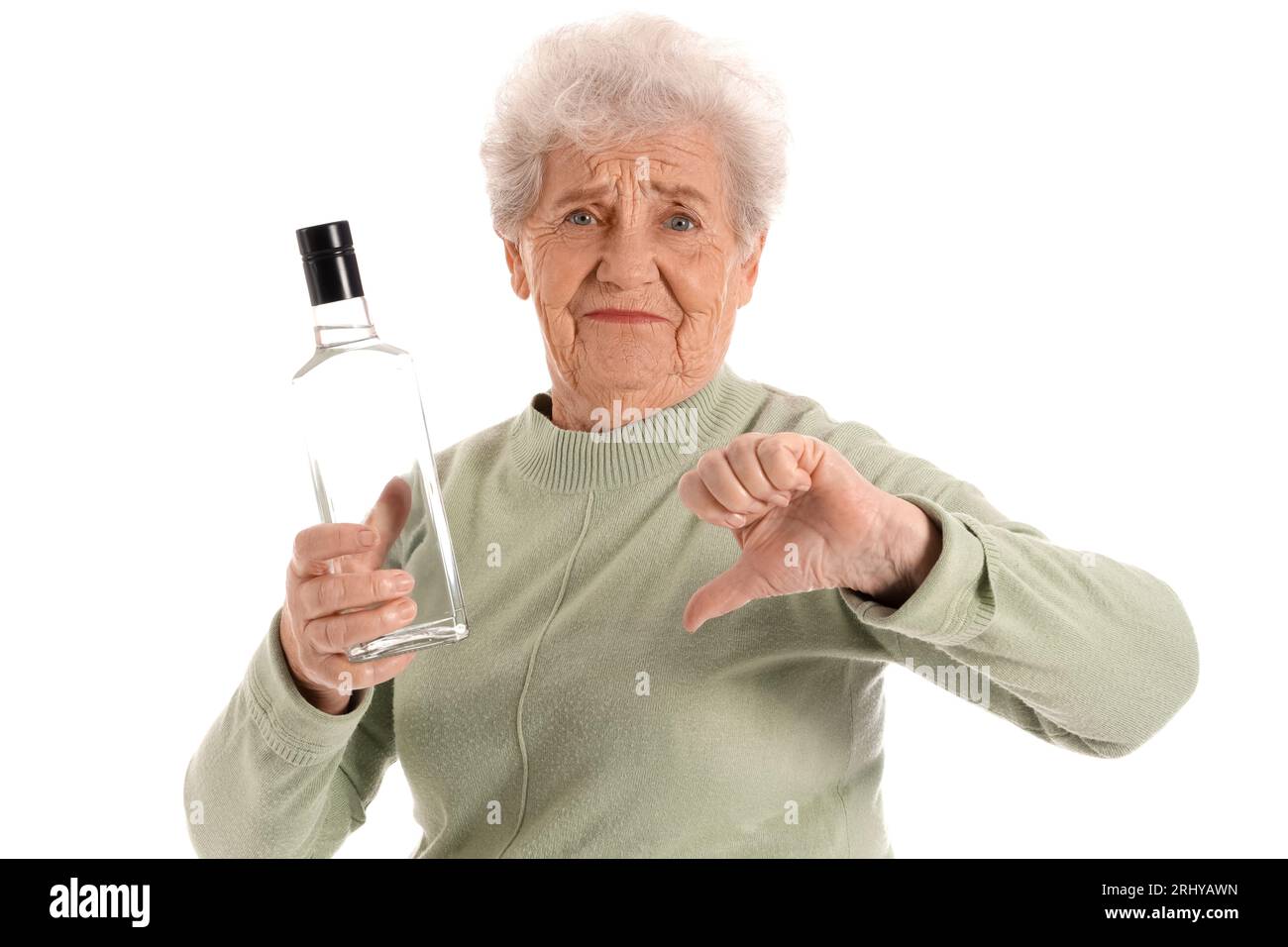Senior woman with bottle of vodka showing thumb-down on white ...