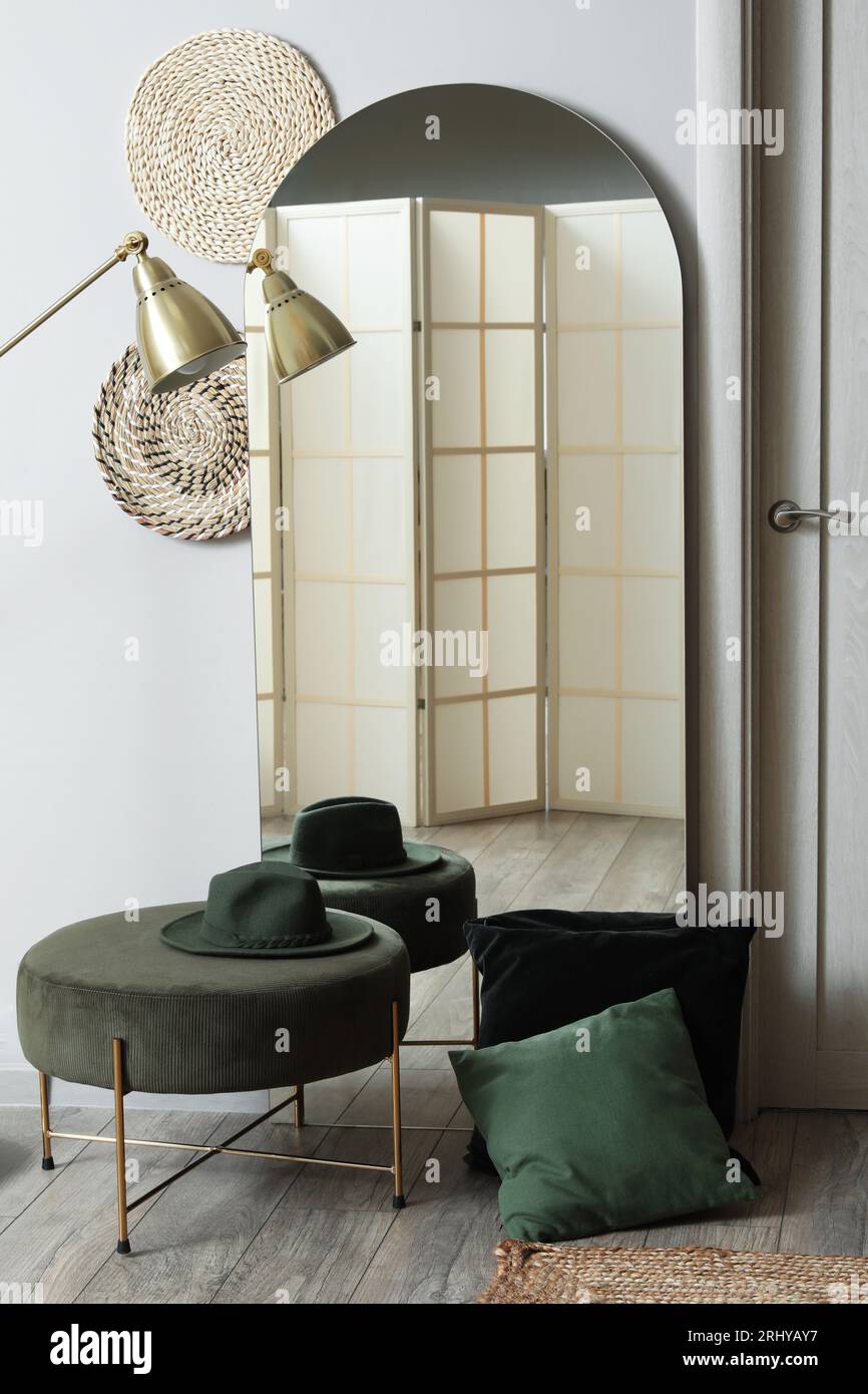 Interior of hallway with mirror, pouf and cushions Stock Photo - Alamy