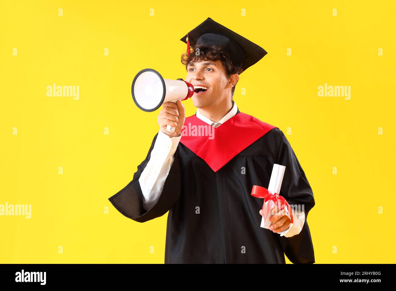 Male graduate student with diploma shouting into megaphone on yellow ...