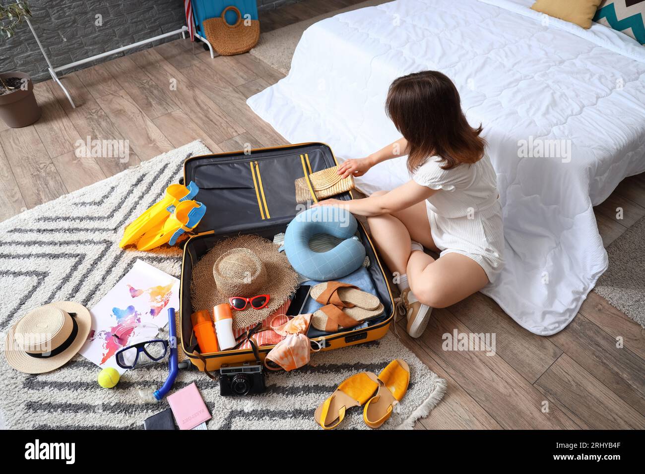 Young woman unpacking things from suitcase in bedroom Stock Photo - Alamy