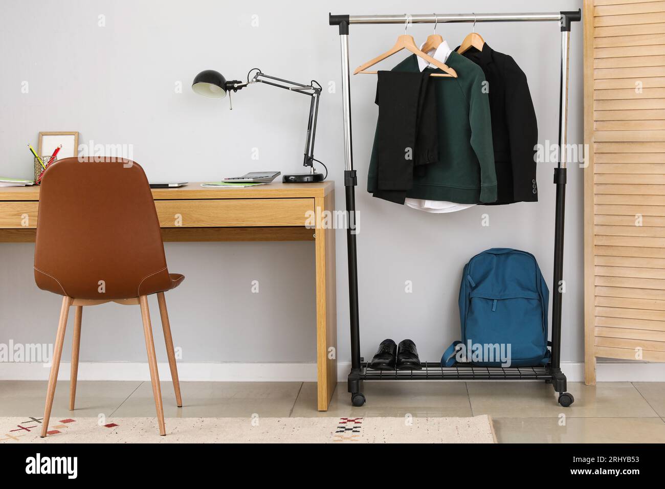 Interior of stylish room with modern workplace and school uniform on ...