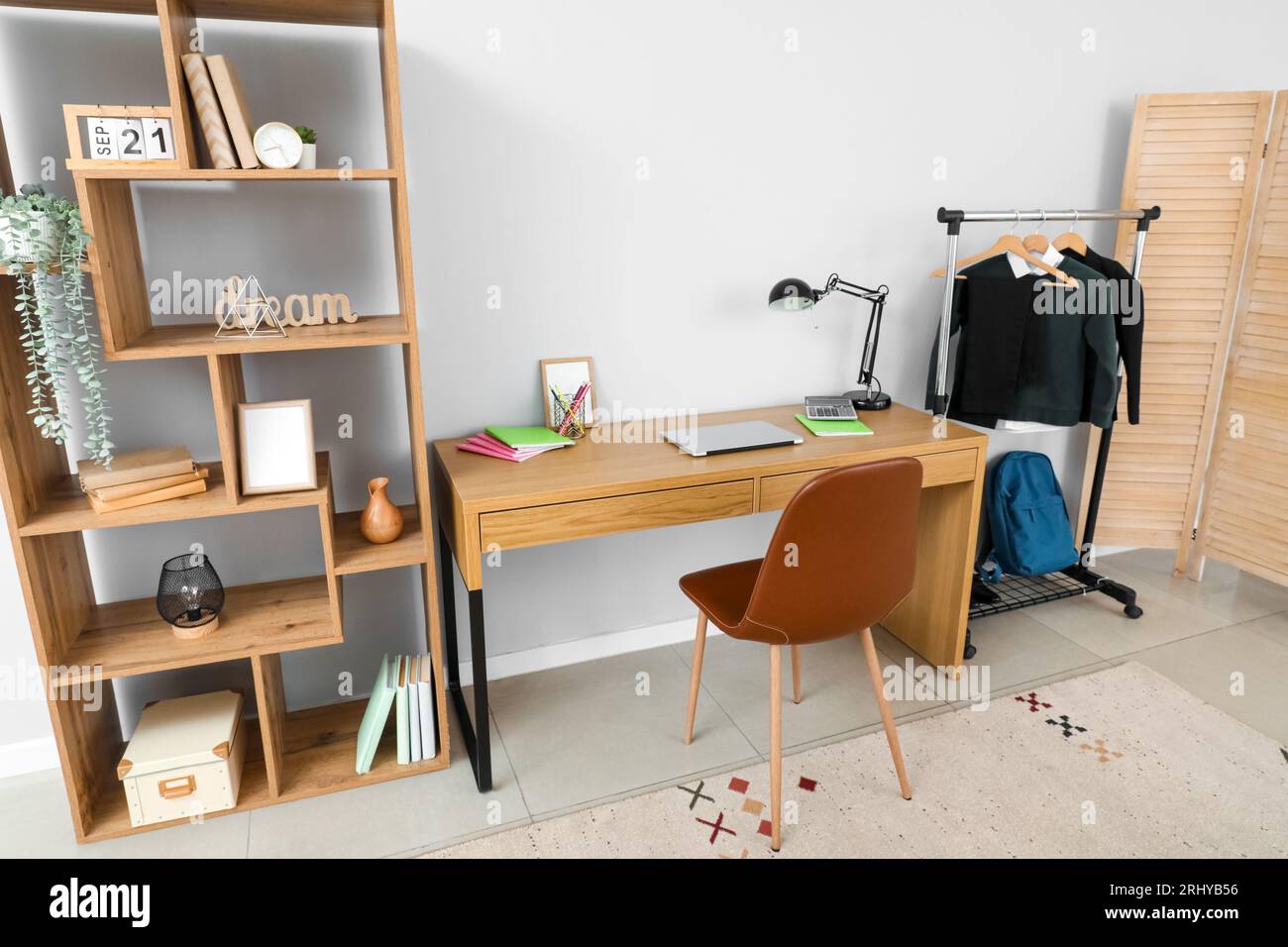 Interior of stylish room with modern workplace and school uniform on ...