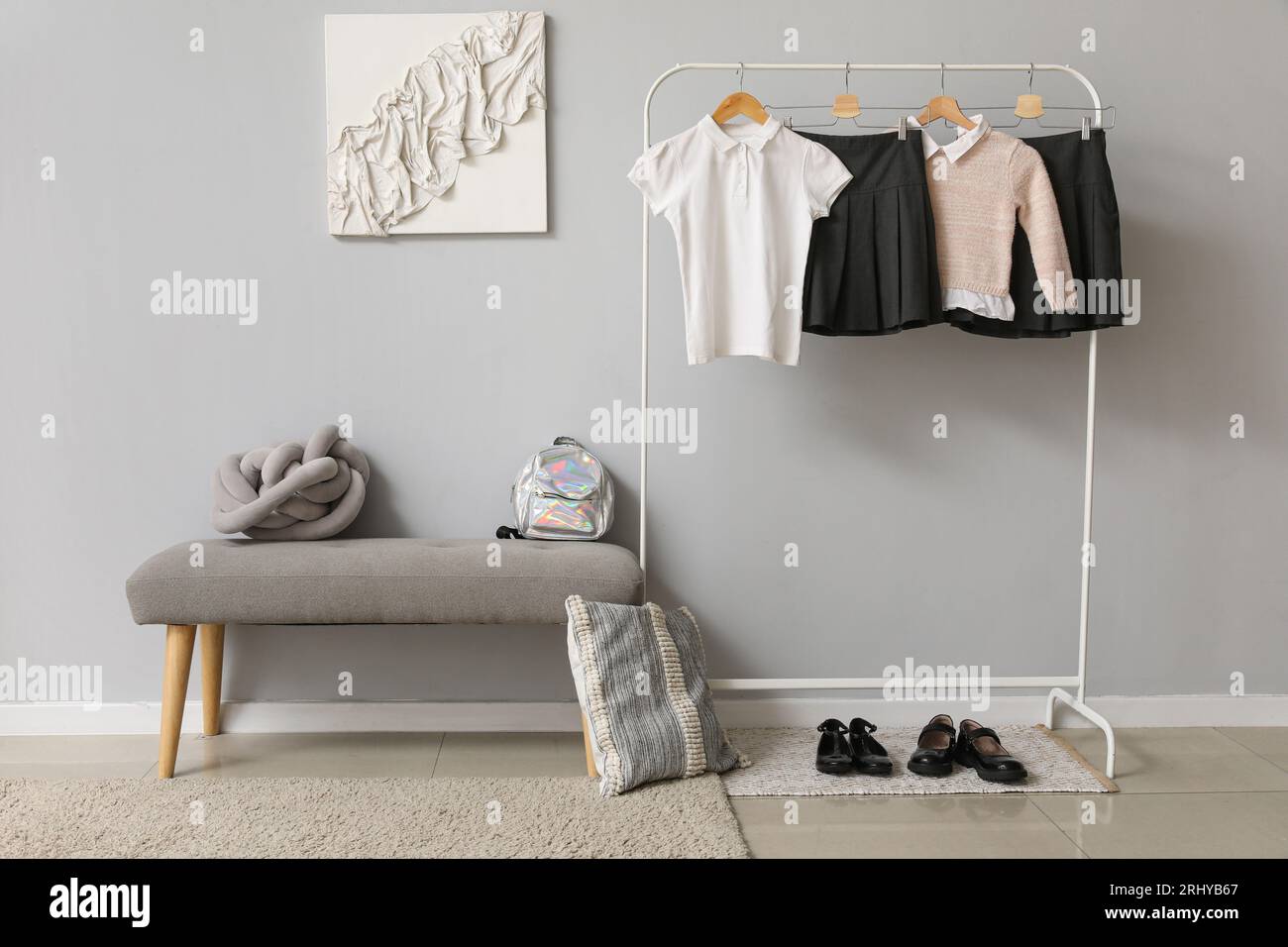 Rack with stylish school uniform near grey wall in room Stock Photo - Alamy