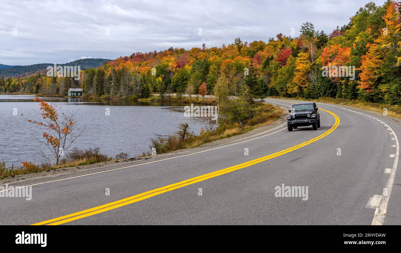 Jeep on Scenic Highway - A Jeep SUV driving along Beaver Pond on ...