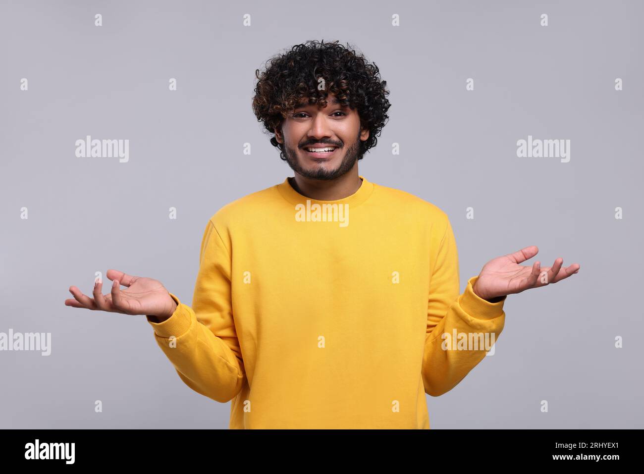 Handsome confused man on light grey background Stock Photo - Alamy