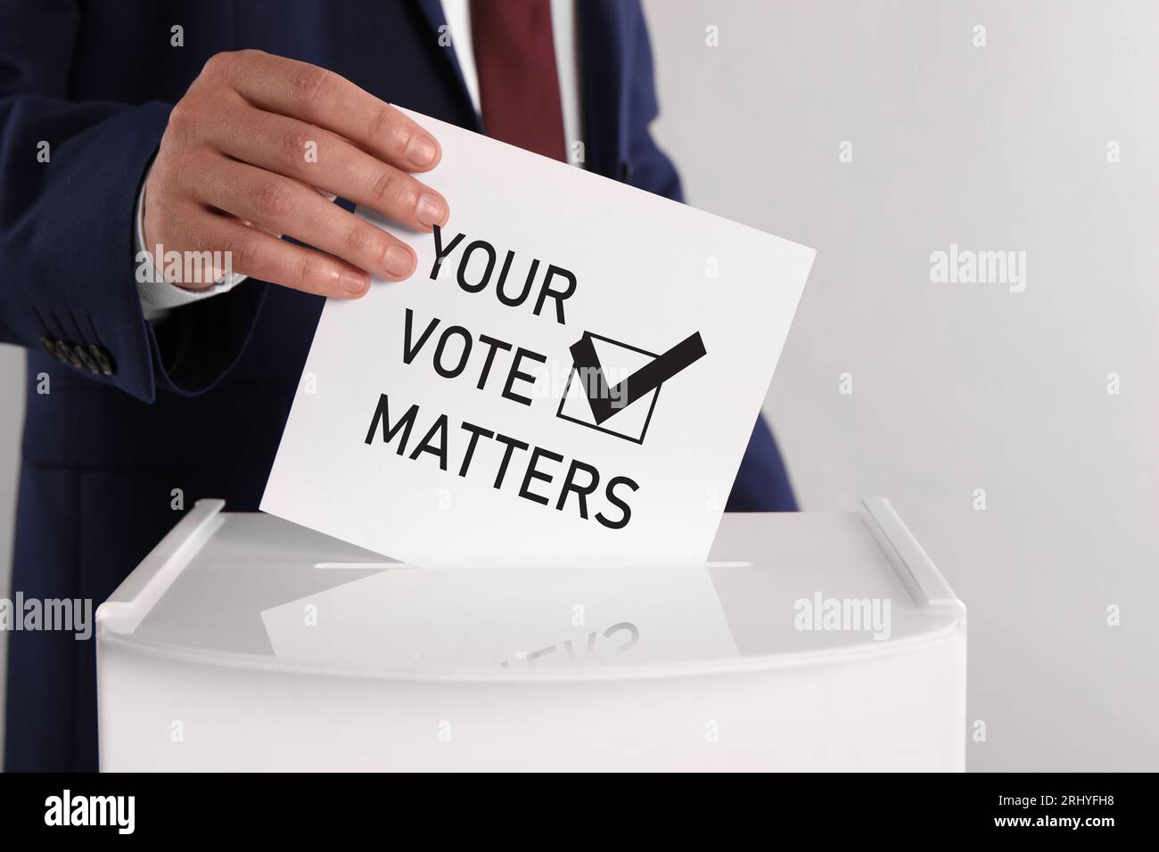 Man putting paper with text Your Vote Matters and tick into ballot box ...