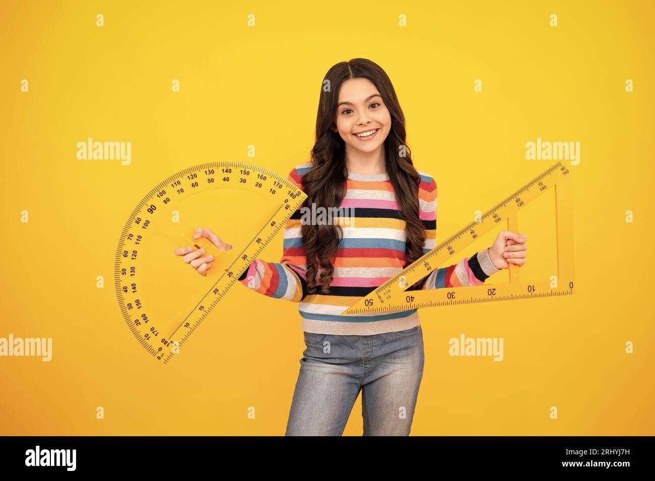 School girl holding measure for geometry lesson, isolated on yellow ...