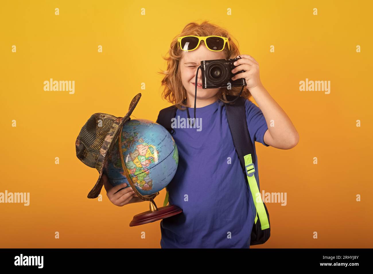Child tourist explorer with globe world. Studio portrait of a little ...