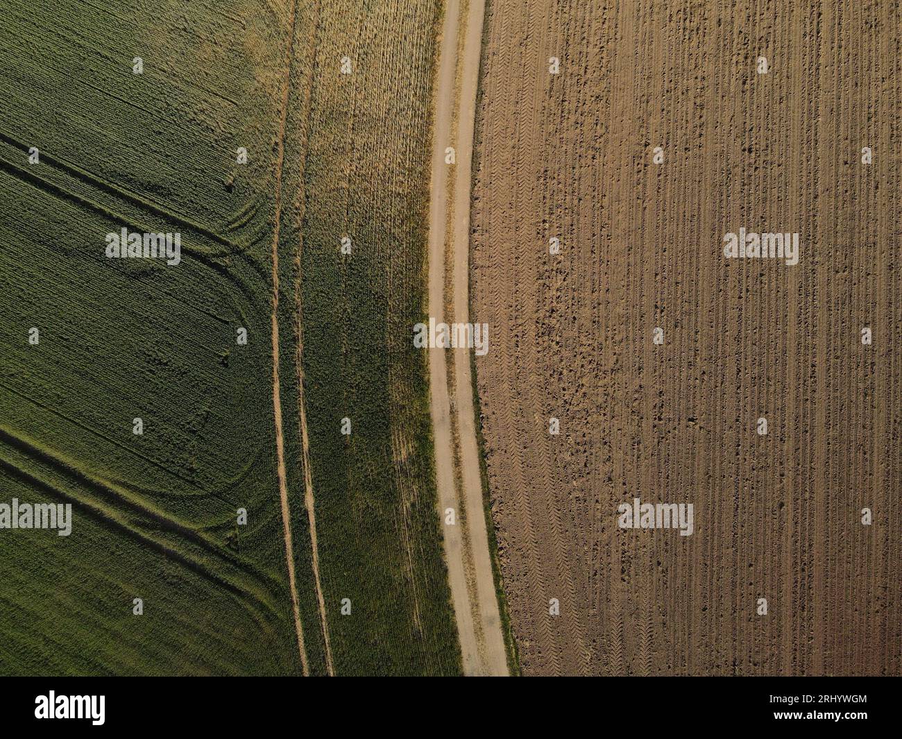 Aerial view of a agriculture land with a plowed dirt field, a dirt road ...