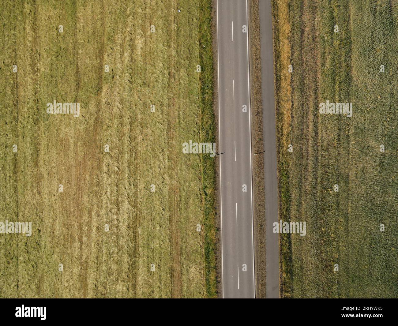 Drone view of a road in the landscape between mowed grass fields Stock ...
