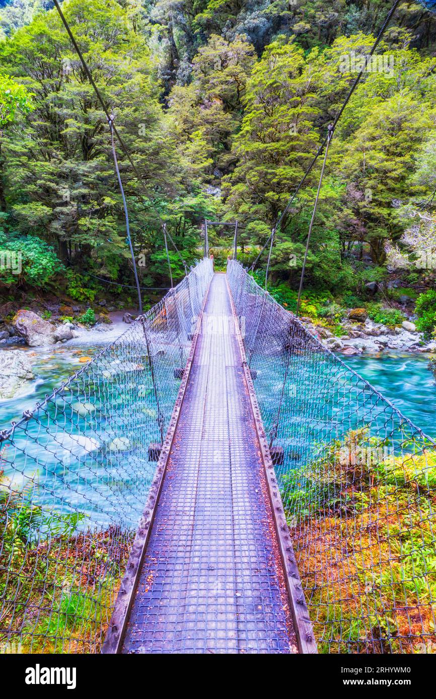Hanging pedestrian bridge across fresh water mouintain river stream on ...