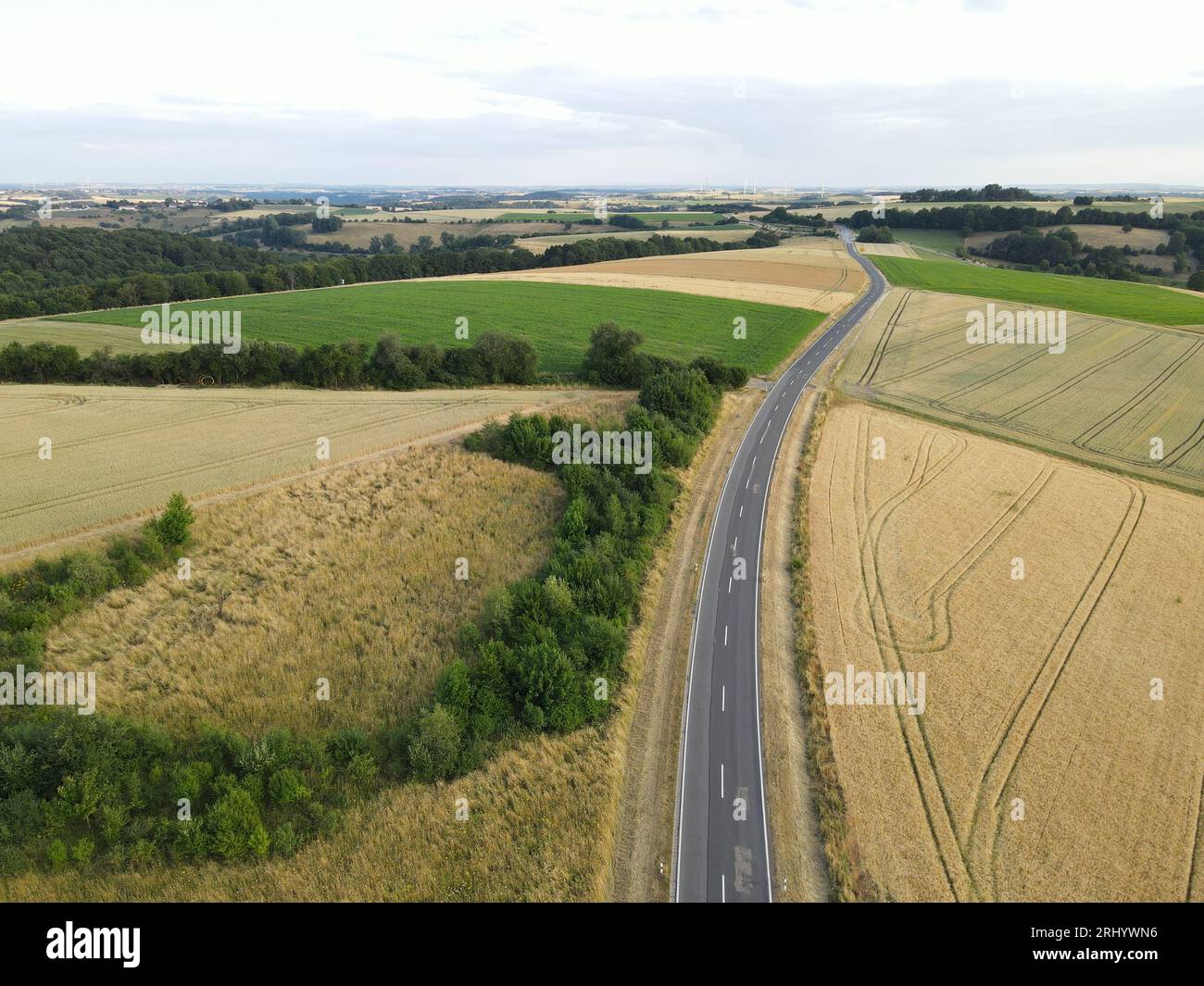 Aerial view of a road between crop and grass fields in the landscape ...