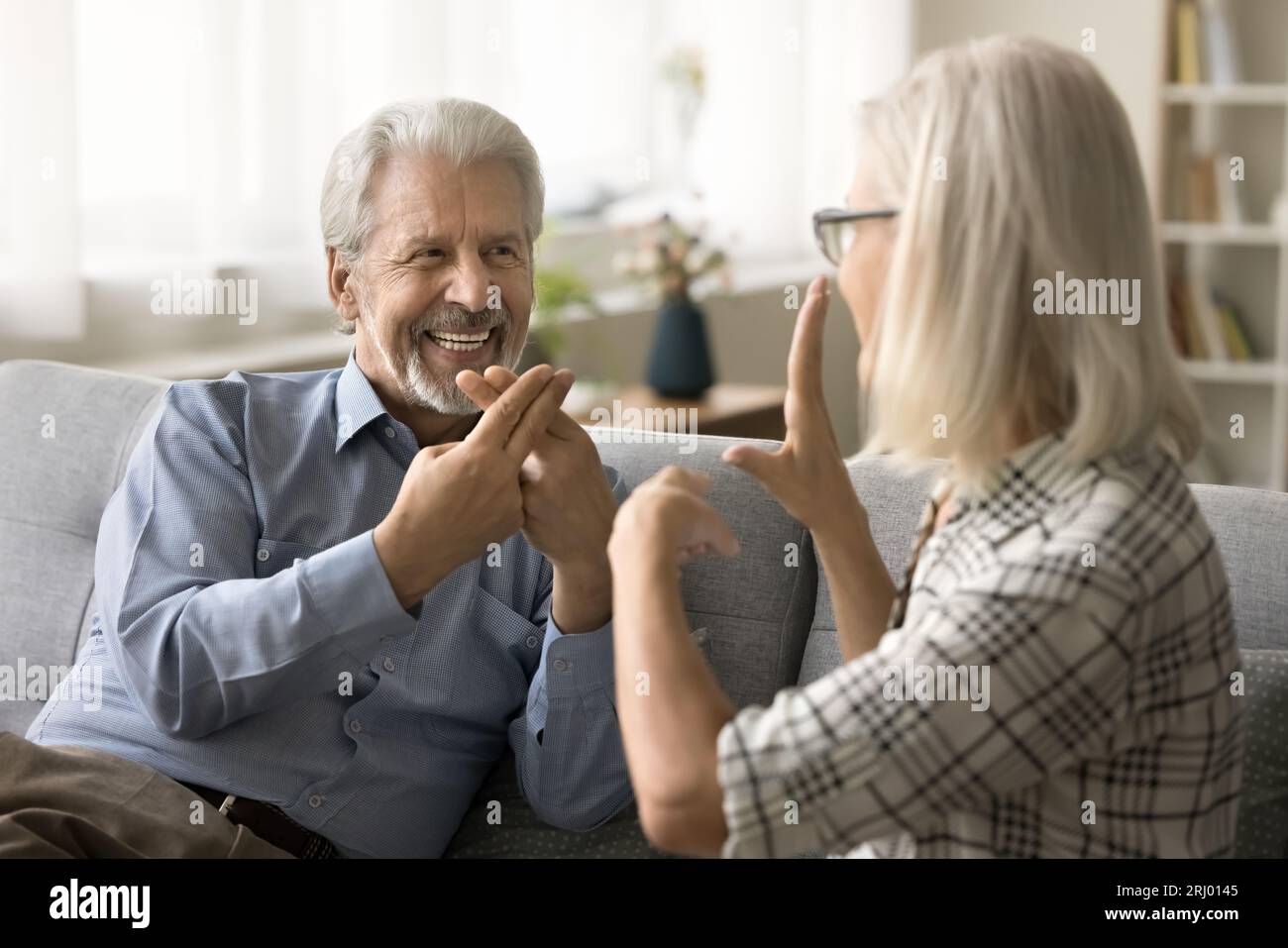Positive senior husband with hearing disorder, disability talking with hands Stock Photo - Alamy