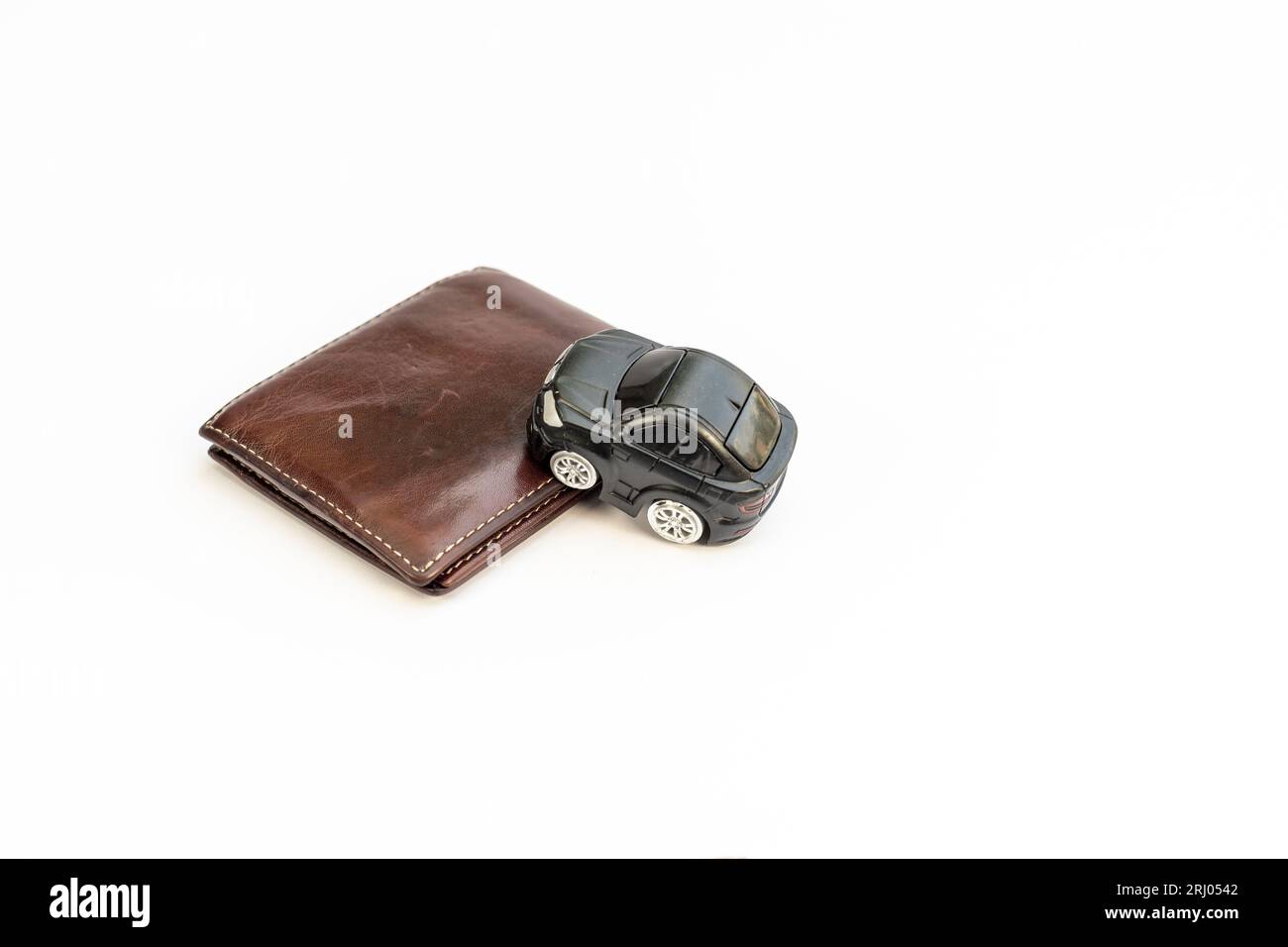 A toy car on a wallet on white background. Car price, cost, loans ...