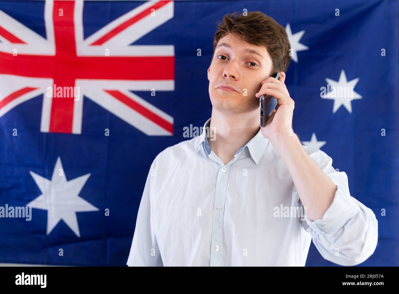 Young guy talking on phone in front of Australian flag Stock Photo - Alamy