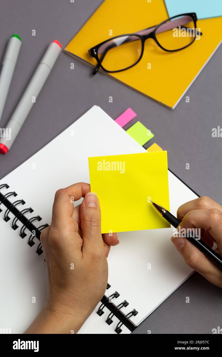 Business planning concept. Hand with a pen and a blank sticker to write ...