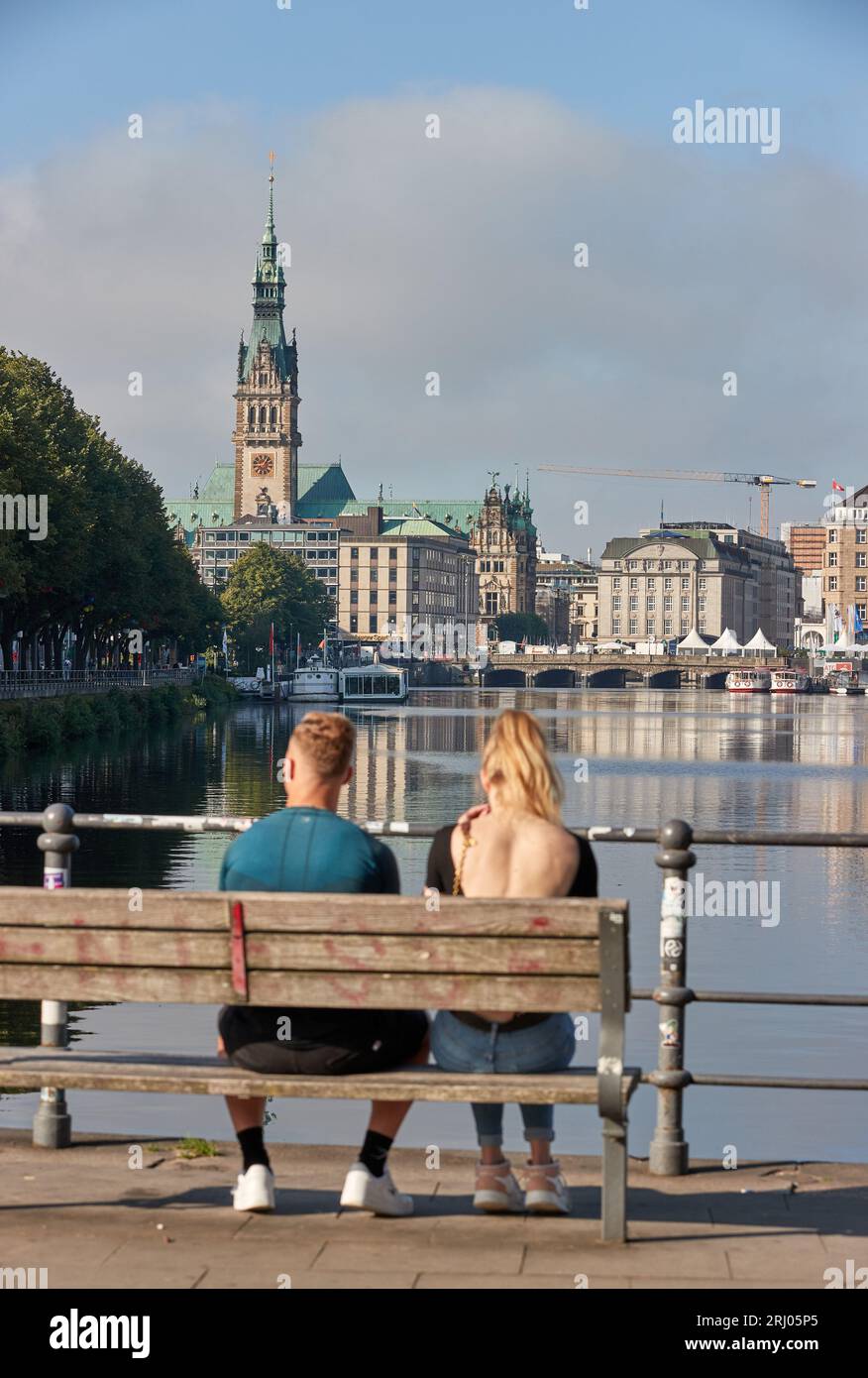Hamburg, Germany. 20th Aug, 2023. A young couple sits on a park bench ...