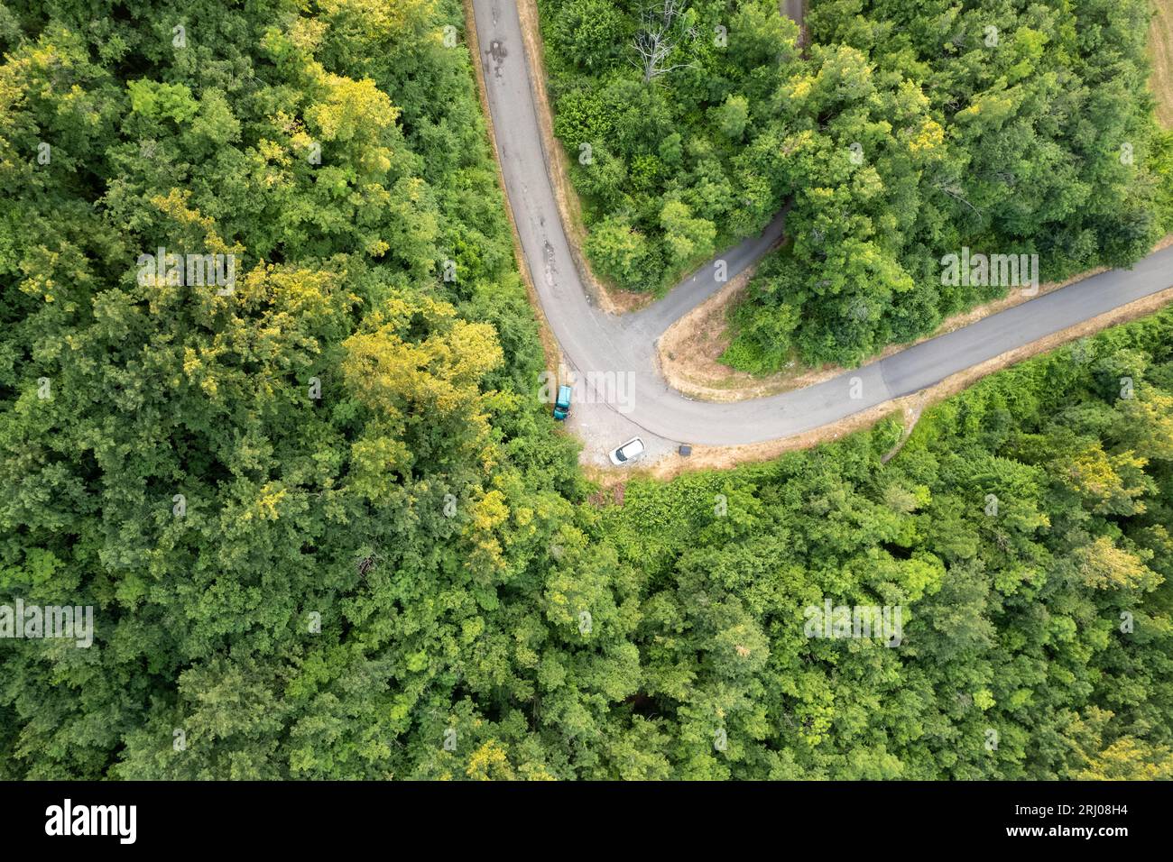 topdown drone cinematic view of serpentine road turns on a mountain ...