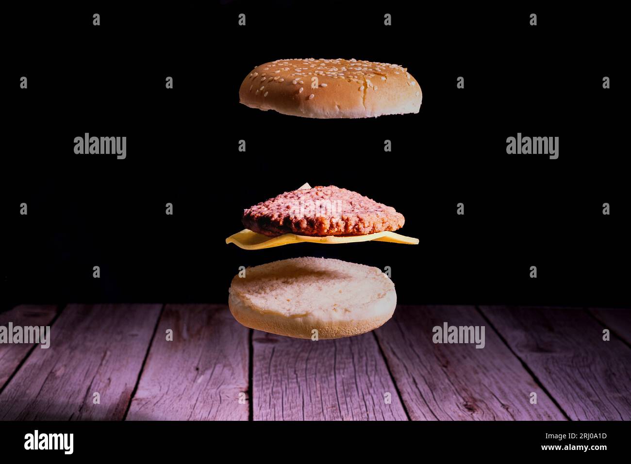 Delicious burger with floating ingredients on the wood table on the ...