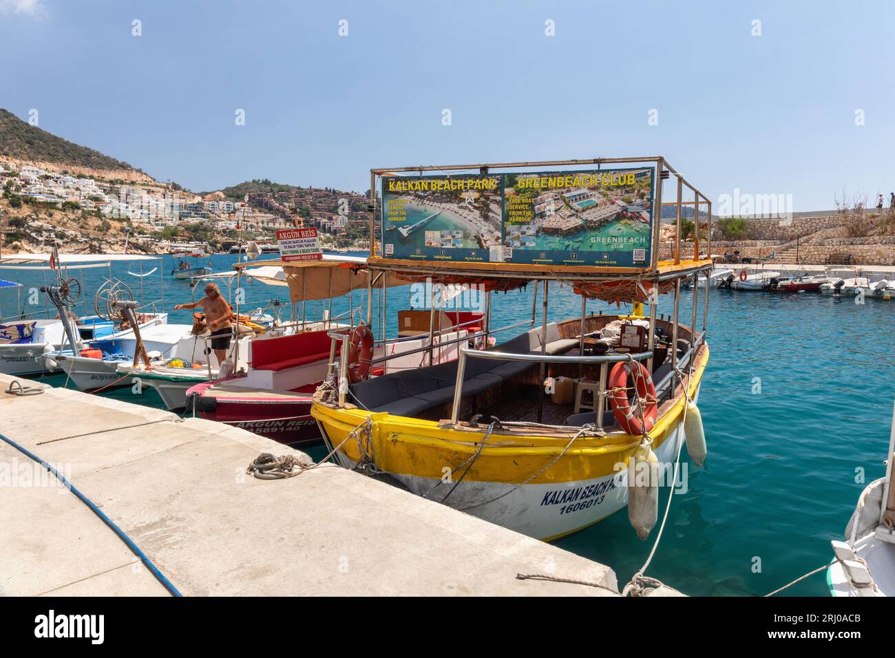 Boat taxi to Kalkan Beach Park next to fishing boats in Kalkan harbour ...