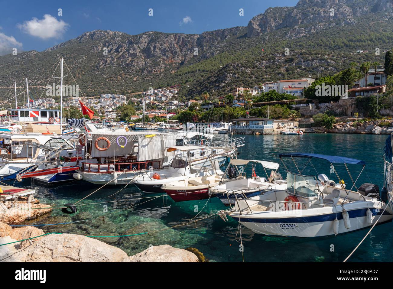 Kas harbour lined with boats and mountains in the background.. Kas is a ...