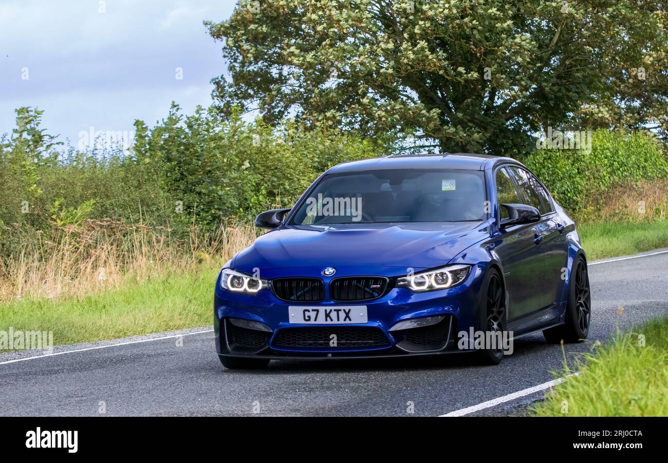 Woburn, Beds, UK - Aug 19th 2023: Blue 2018 BMW M3 car travelling on an English country road ...