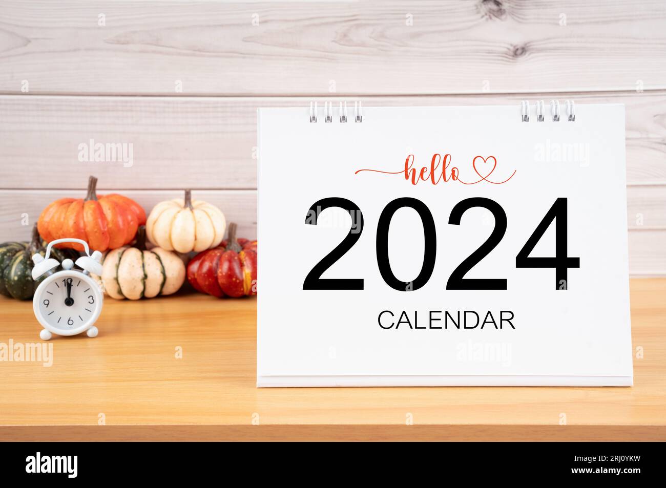 Desktop calendar for 2024 year and heap pumpkins with clock on wooden ...