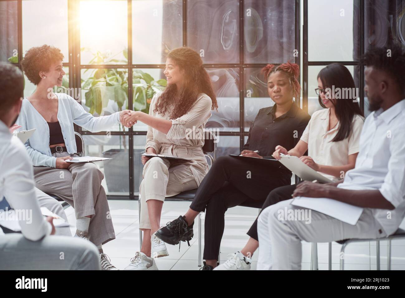 Welcome aboard. Group of business people sitting on a chair while two ...
