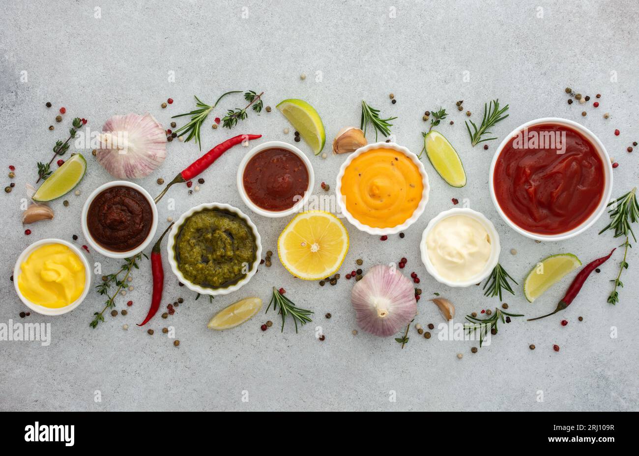 Different types of sauces in bowls with seasonings, rosemary and pepper ...