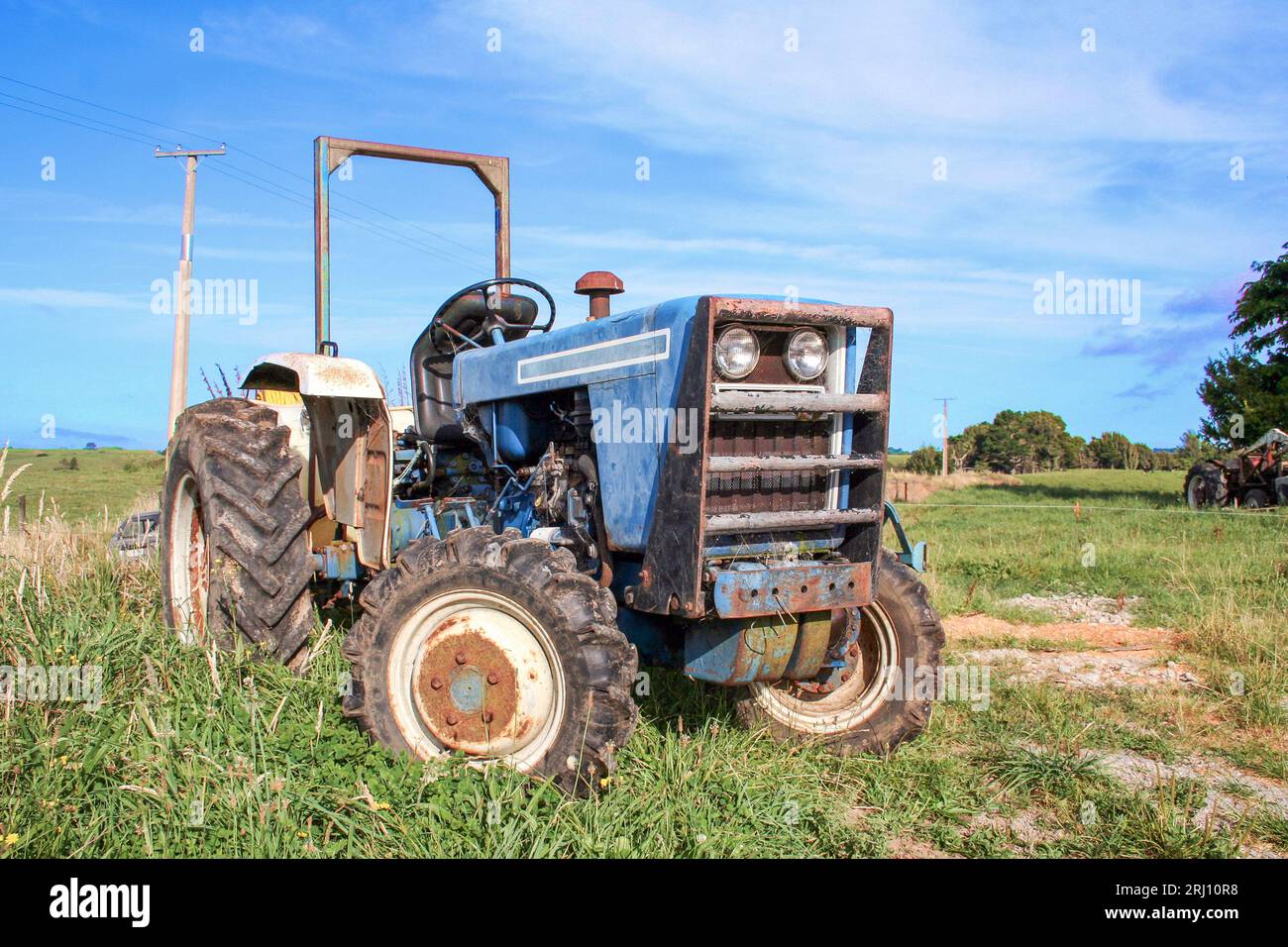 Low angle view of an old blue tractor with signs of mild rust. Situated ...