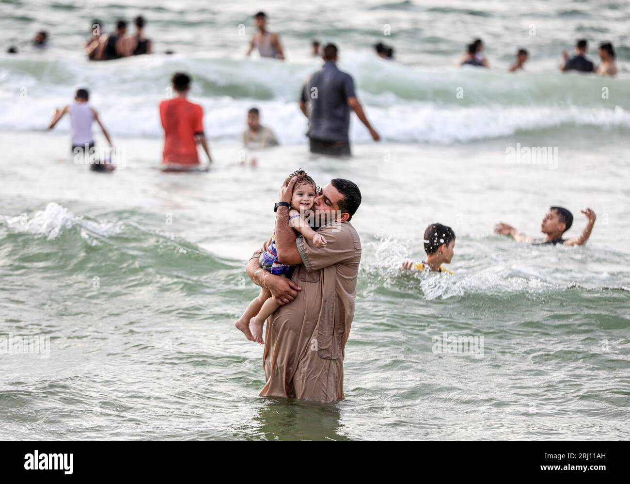 Gaza, Palestine. 18th Aug, 2023. A Palestinian man carries his child on ...