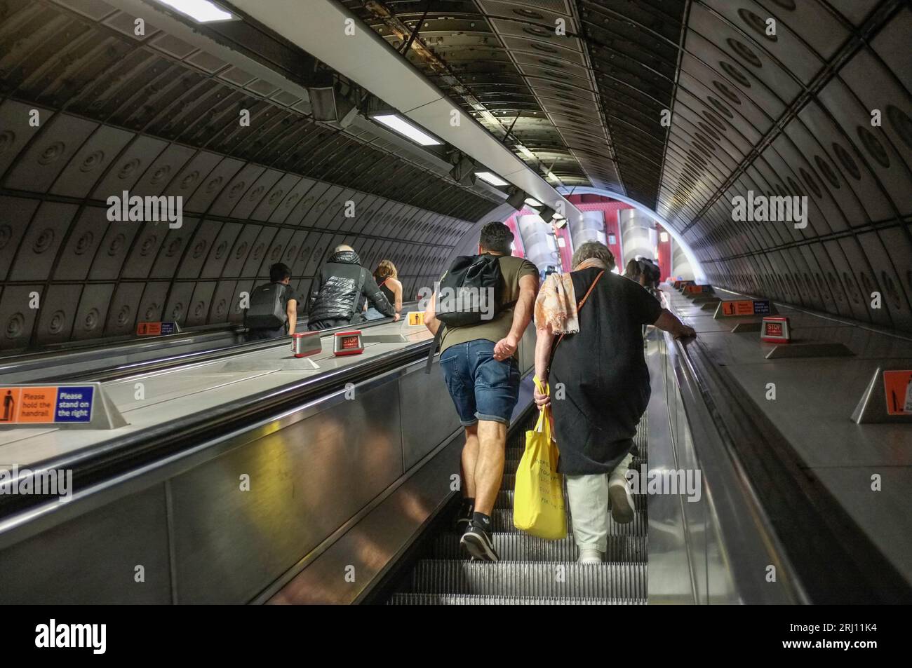 commuters, shoppers and tourists going up the escalator on the ...