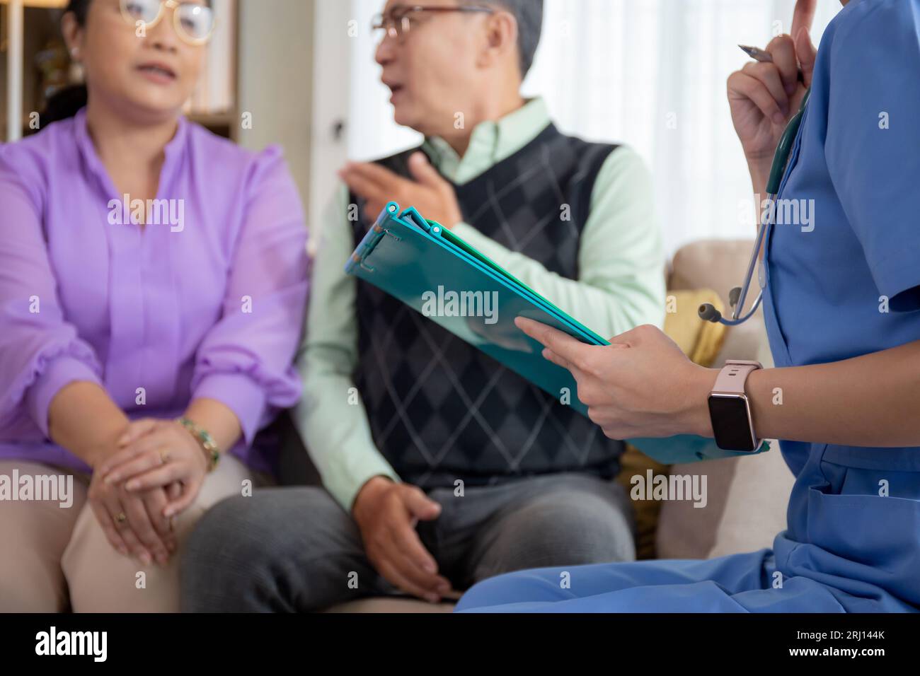 Caregiver sitting on sofa checkup and diagnostic with elderly couple ...