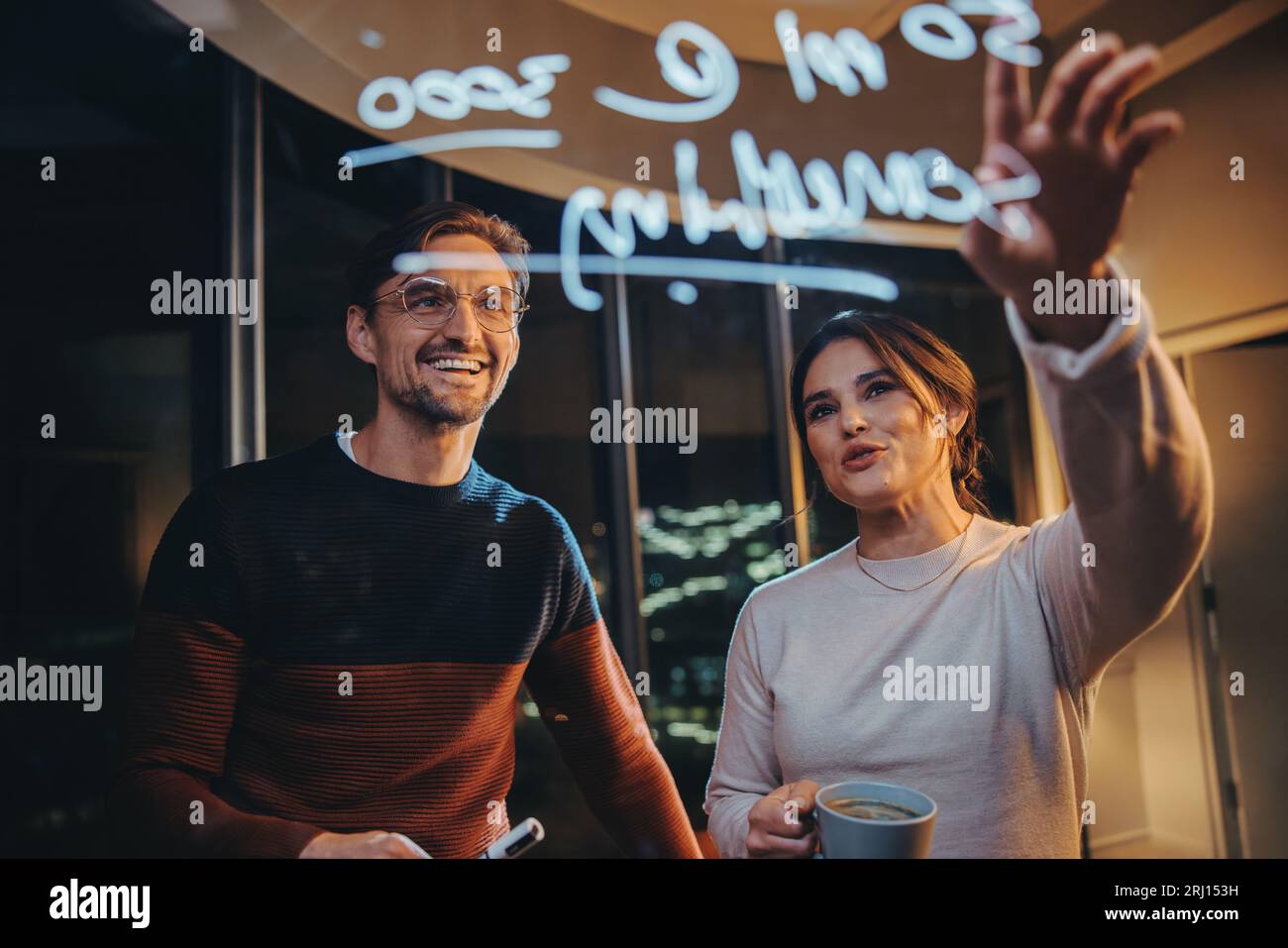 Two business professionals have a late-night discussion in an office ...