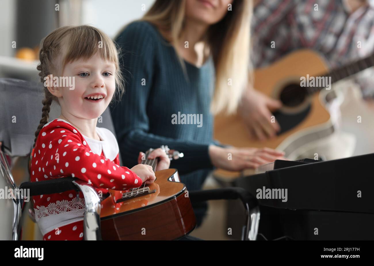 Baby learns play musical instruments with parents Stock Photo - Alamy
