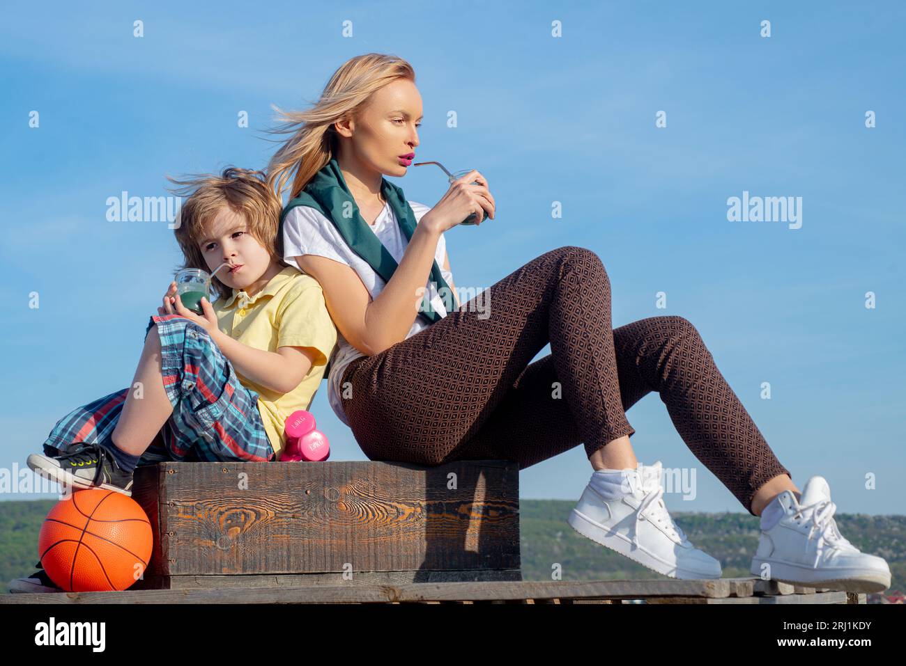 Sporty healthy child and mother drink smoothie after workout. Family ...