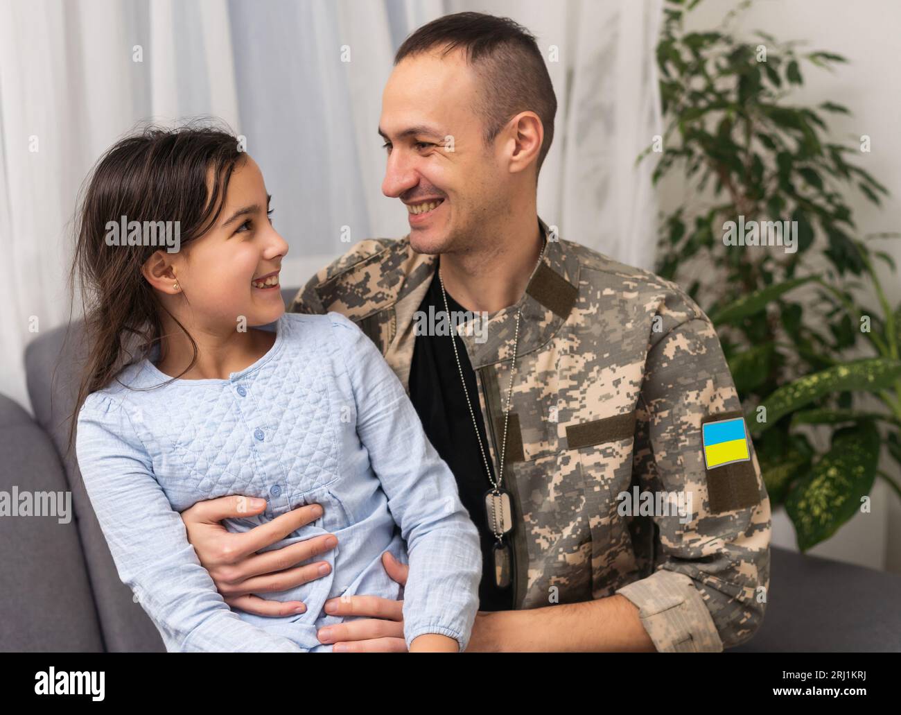 Soldier in Ukrainian military uniform hugging his daughter. Family ...