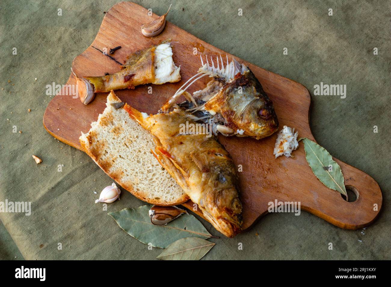 Leftovers of fried fish on a barbecue, messy food after meal close-up ...