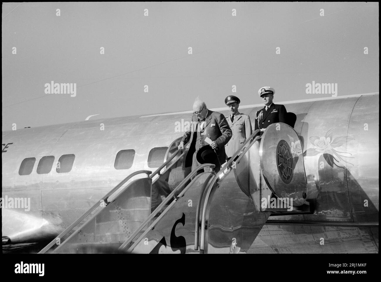 Winston Churchill coming down the steps of an airplane during his ...