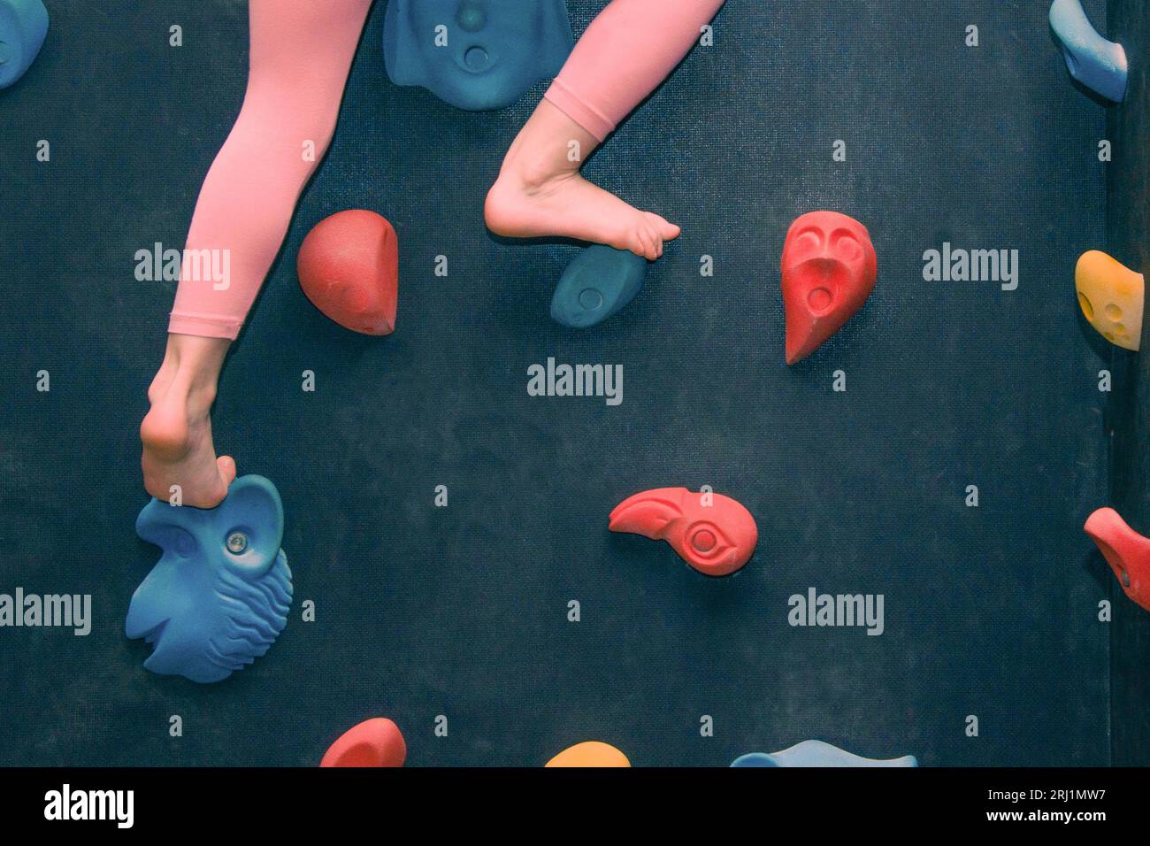A child girl climbs barefoot a climbing wall Stock Photo - Alamy