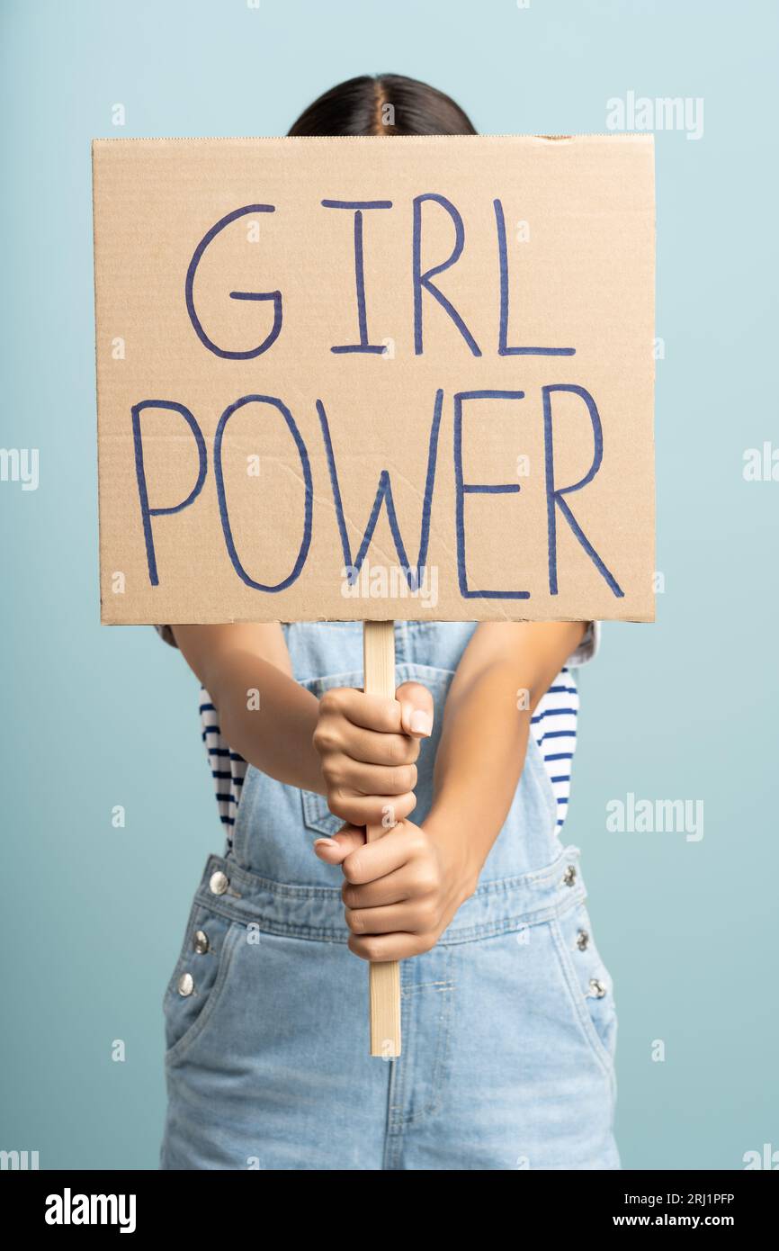 Anonymous woman holding banner GIRL POWER slogan isolated on studio ...