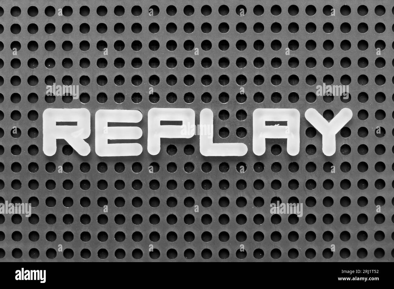 White alphabet letter in word replay on black pegboard background Stock ...
