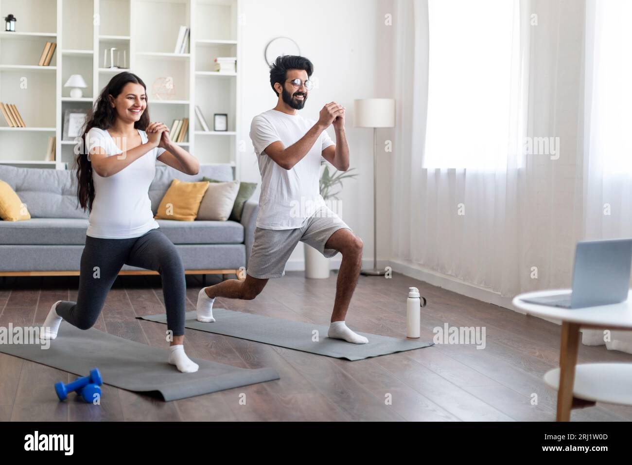 Training At Home. Indian couple doing glutes exercice in front of ...