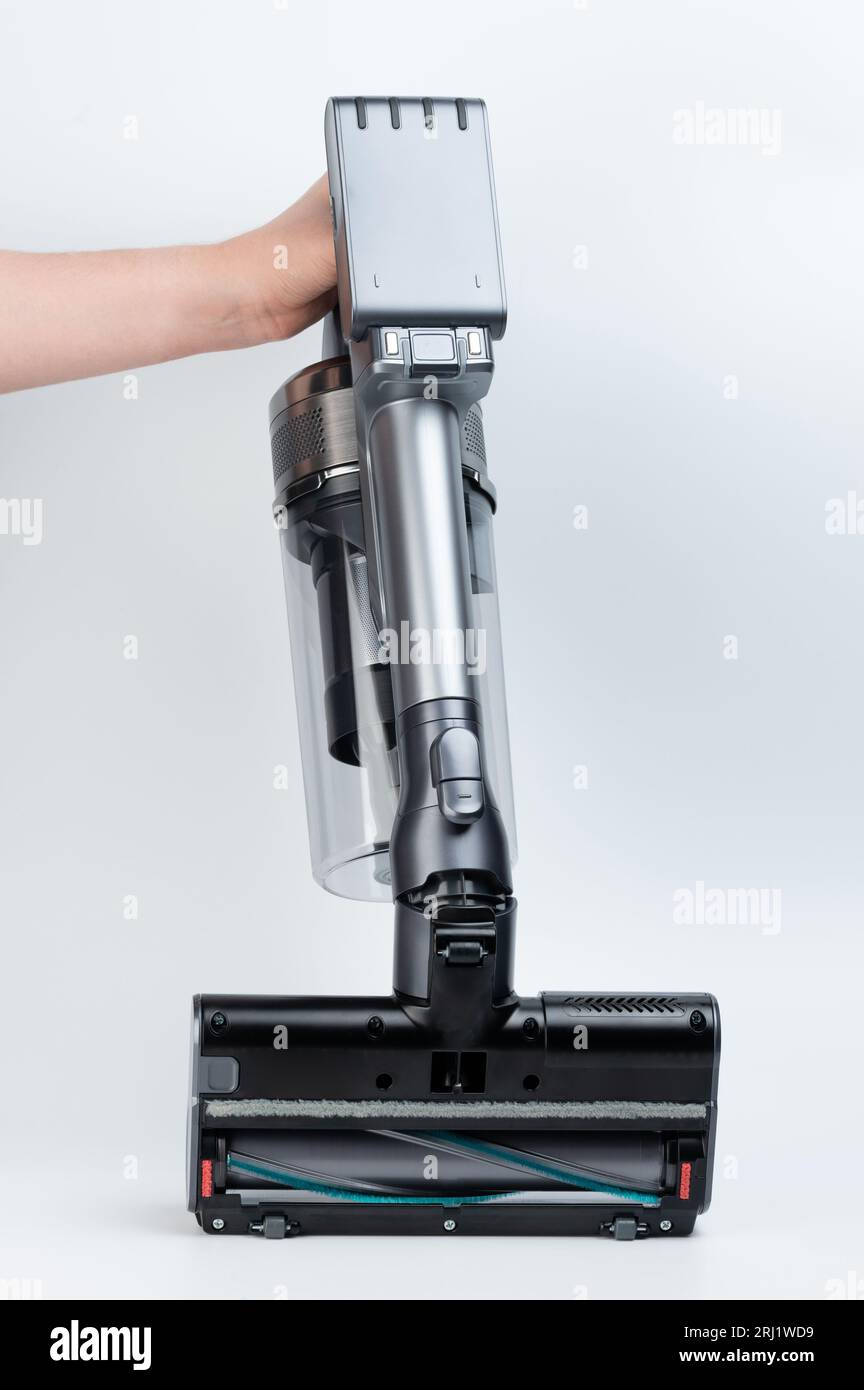 Portable vacuum clener in hand with brush sweep bottom side isolated on ...