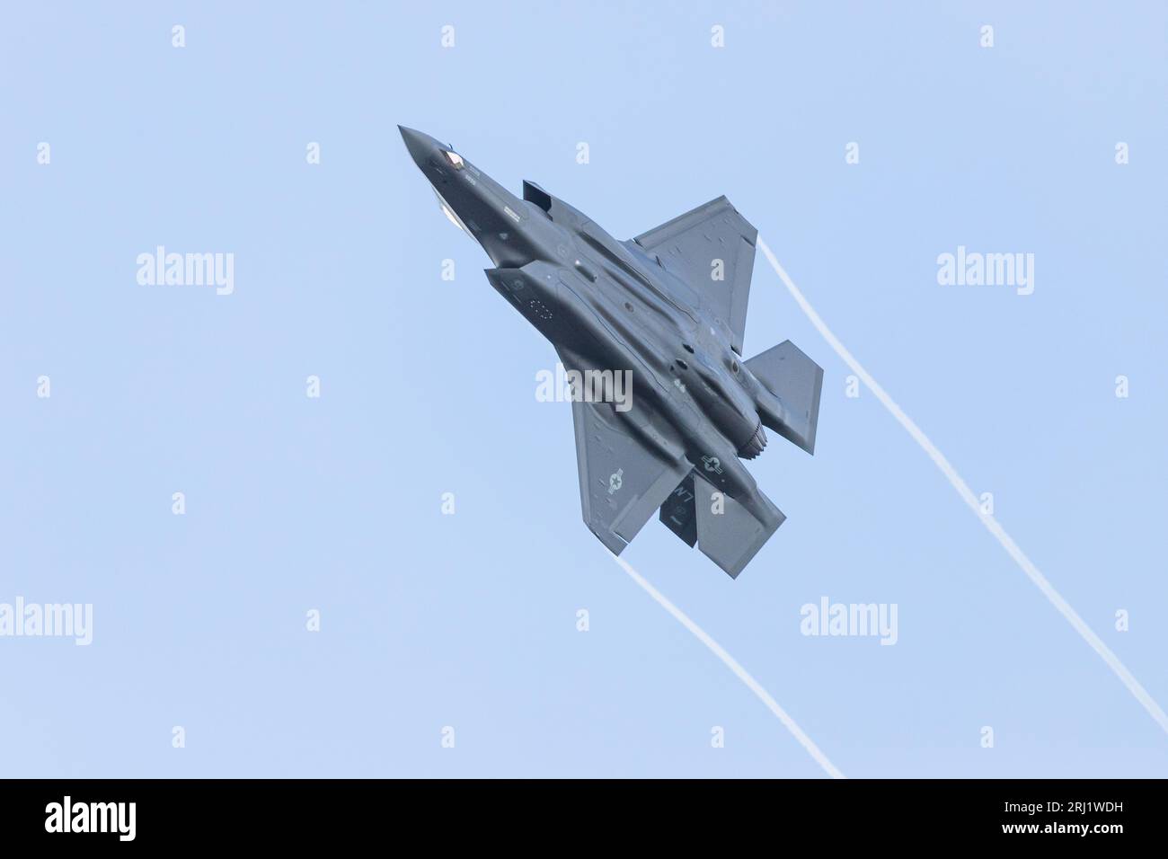 An F-35A Lightning II seen trailing vapour from its wing tips departs ...