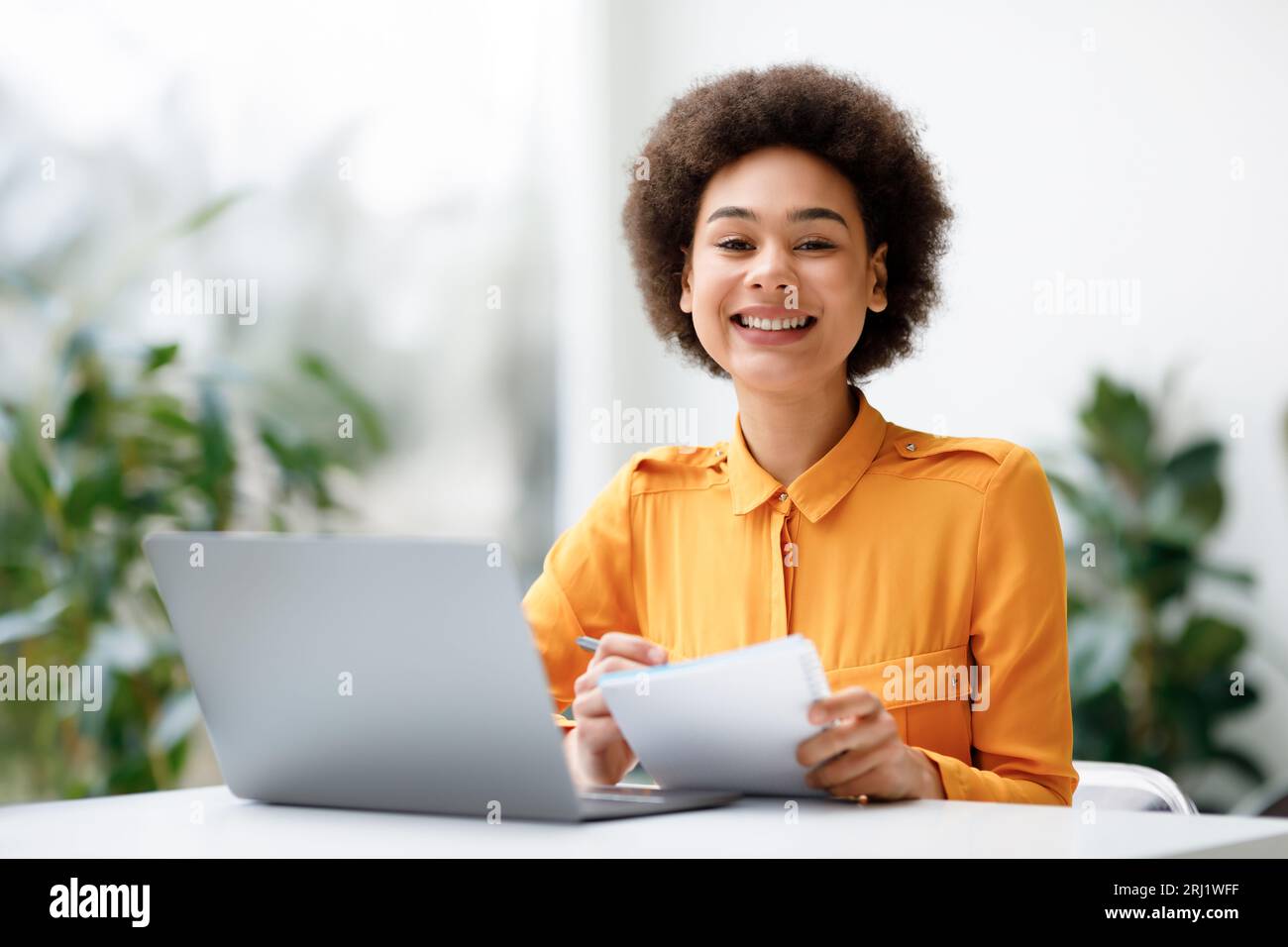 Happy black female student engaging in distance learning via laptop ...