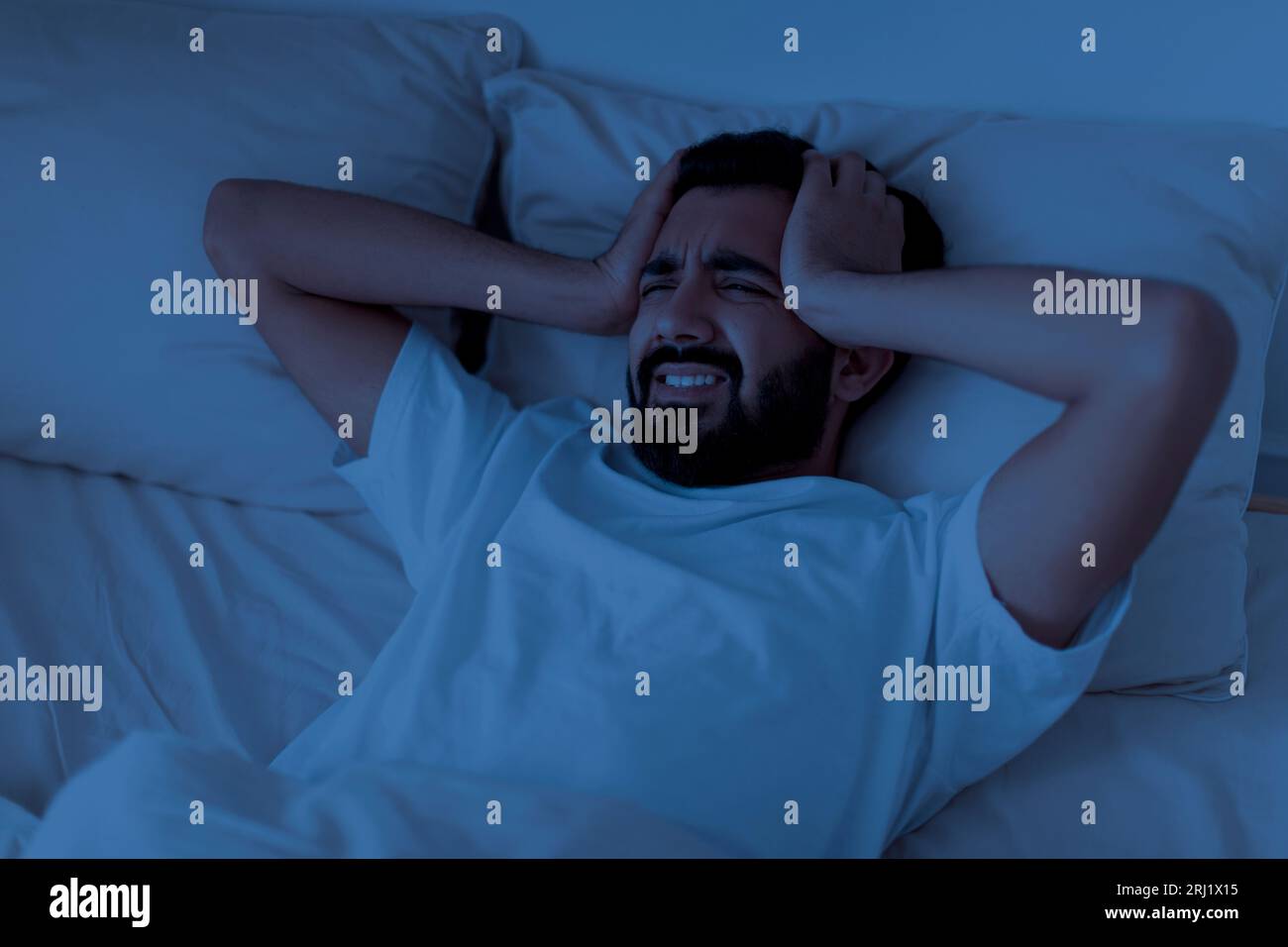 Sleepless indian guy suffering acute headache while lying in bed at ...