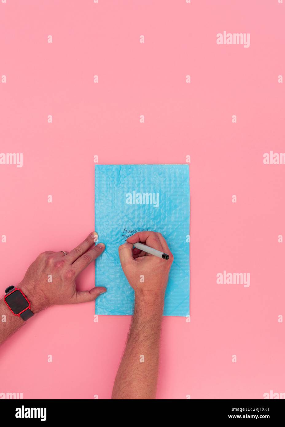 Overhead view of Caucasian adult male hands writing a shipping address ...